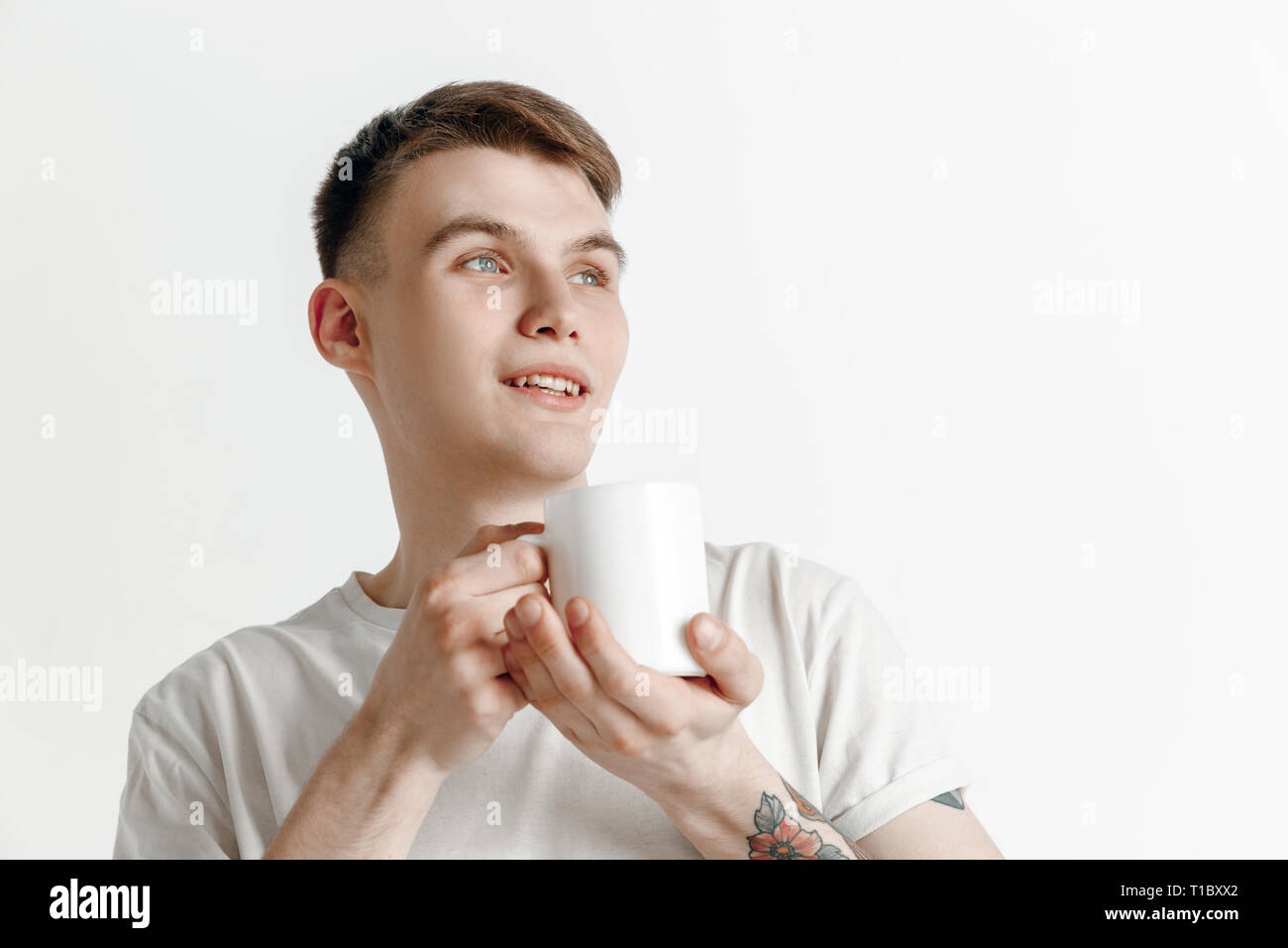 Taking a coffee break. Handsome young man holding coffee cup, smiling ...
