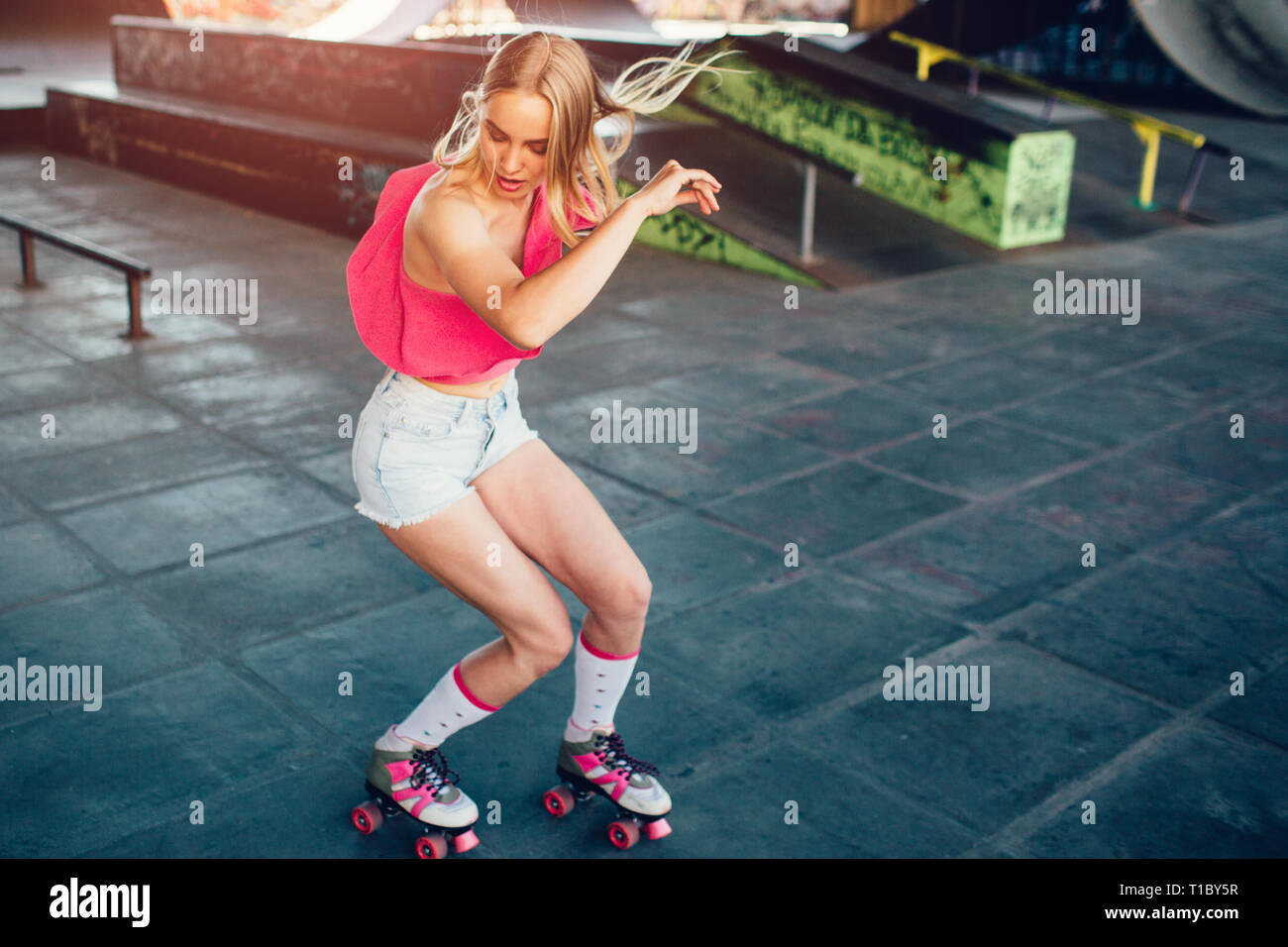 Beautiful Blonde Girl Is Doing Some Tricks During Rollerblading She Is Standing In A Squat
