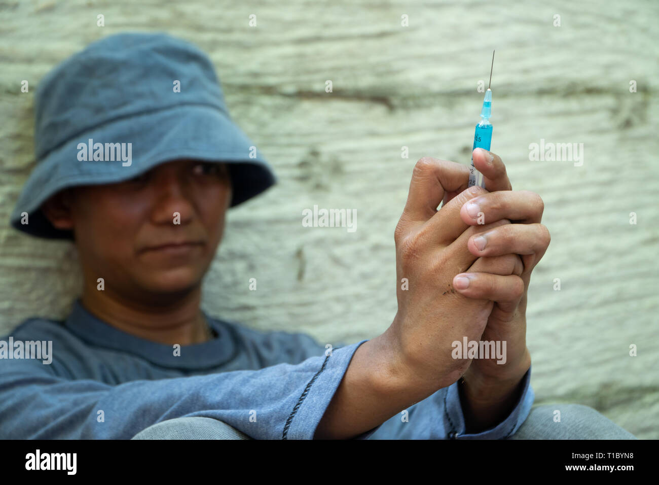 close up of Syringe and Needle in hand of drug addict man. homeless ...