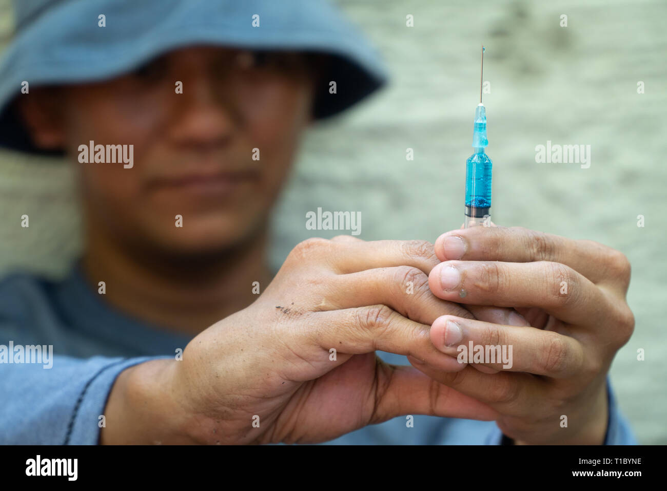 close up of Syringe and Needle in hand of drug addict man. homeless ...
