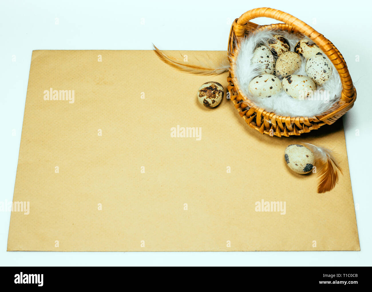 Small basket with quail eggs stand on old paper for your text. Top view ...