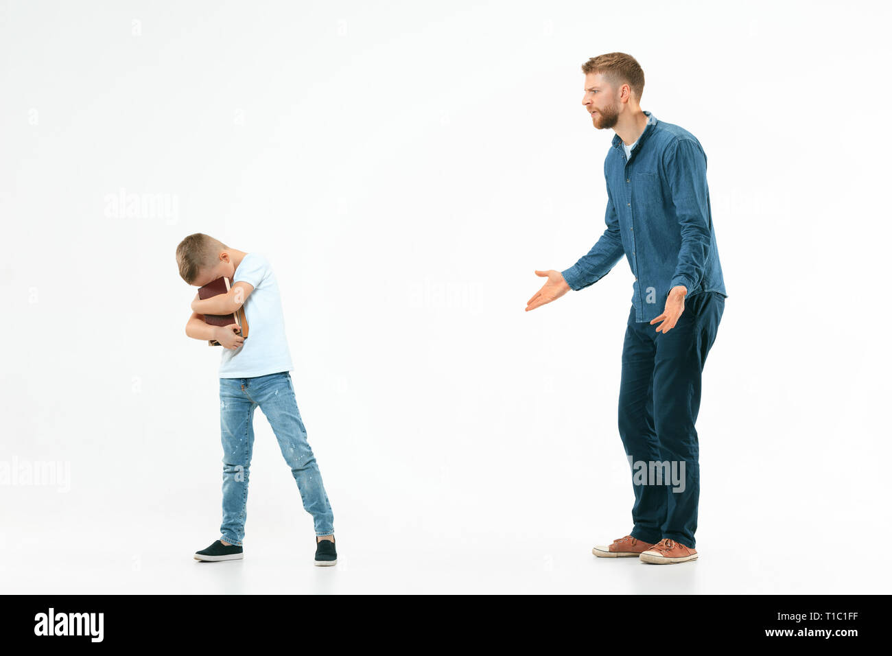 Angry father scolding his son at home. Studio shot of emotional family ...