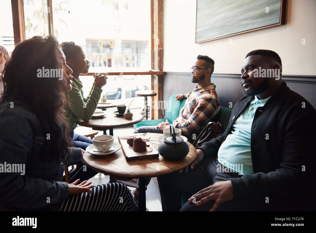 Diverse friends talking together over coffee in a cafe Stock Photo - Alamy