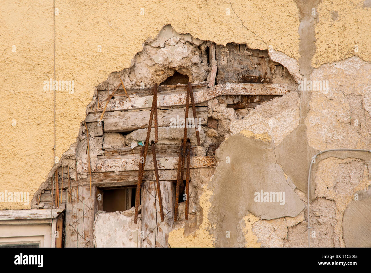 Hole in the wall of a house in plaster with bricks and iron beams Stock ...