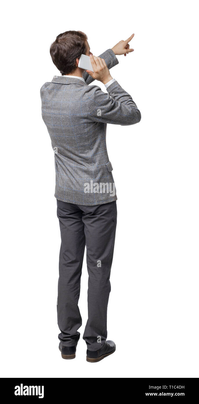 back view of pointing business man in suit talking on mobile phone ...
