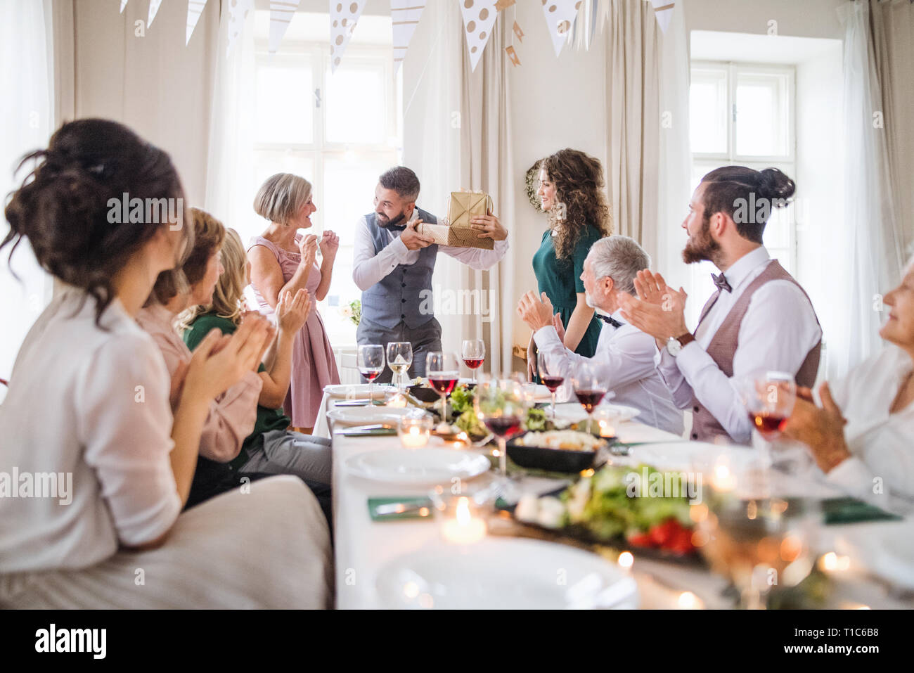 A woman giving gift to a mature man on a family birthday party Stock ...