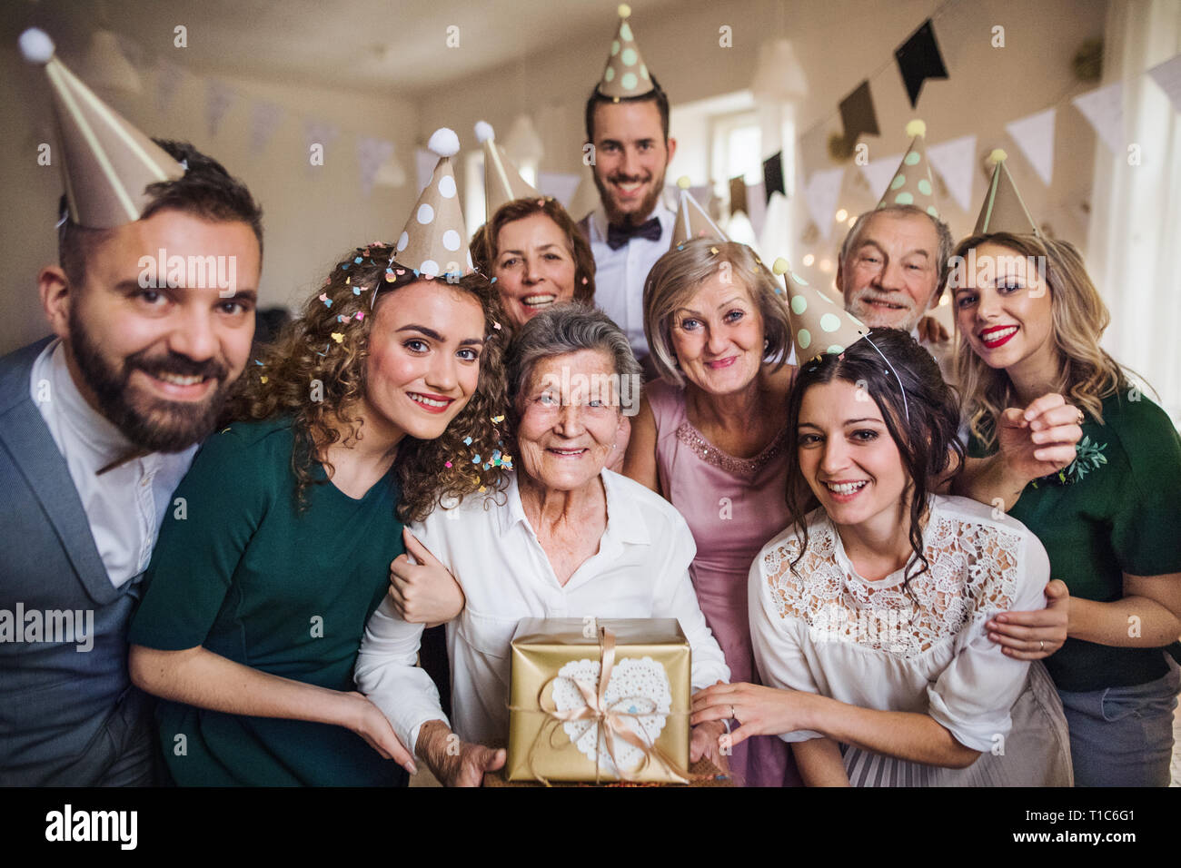 A portrait of multigeneration family with presents on a indoor birthday ...