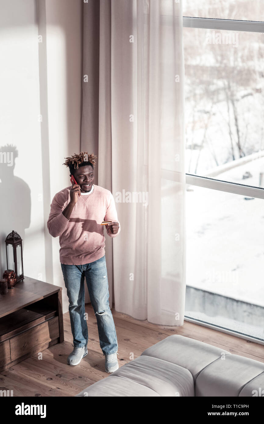 Online consultation. Pleased male keeping smile on his face while ...