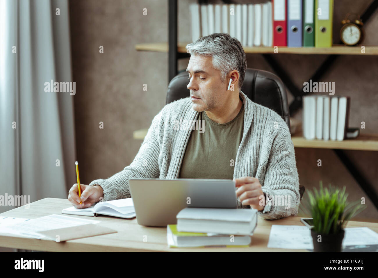 Serious nice man writing in his notebook Stock Photo - Alamy