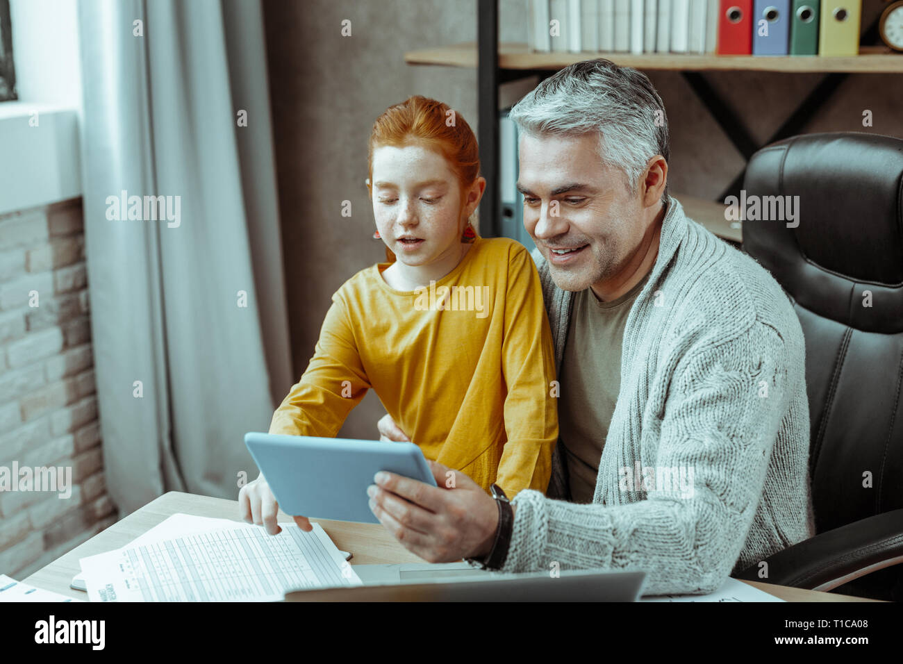 Positive cheerful man looking at the tablet screen Stock Photo - Alamy