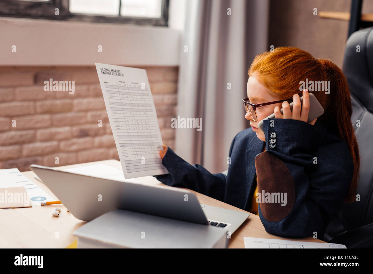 Good looking serious girl looking at the document Stock Photo - Alamy