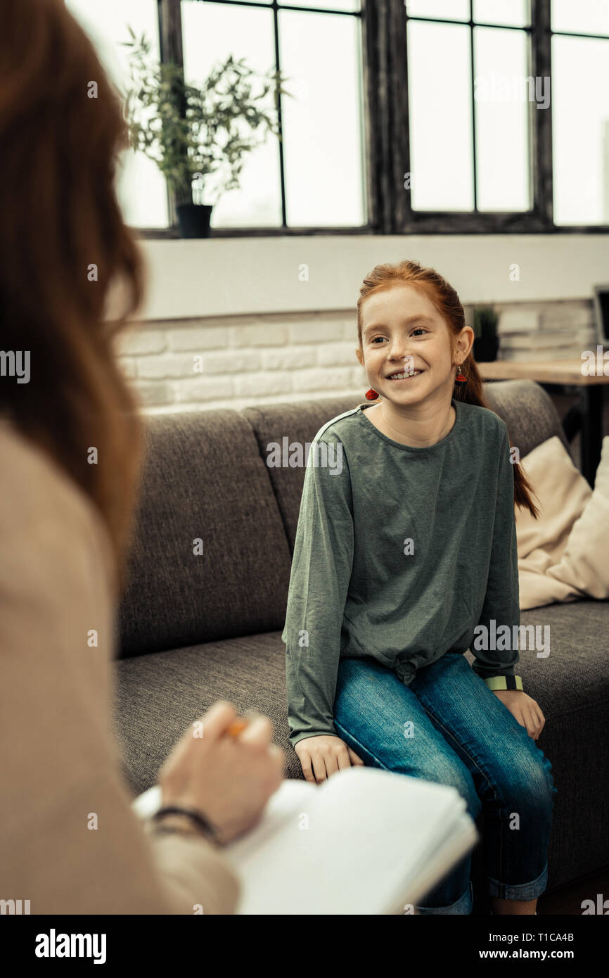 Joyful nice girl sitting on the sofa Stock Photo - Alamy