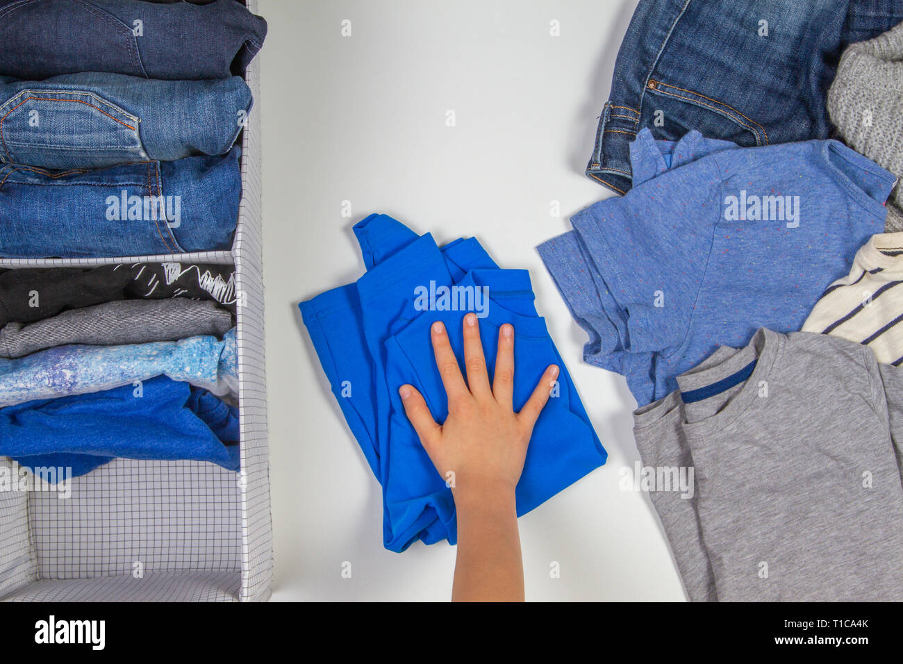Vertical storage of clothing, tidying up, room cleaning concept. Hands ...