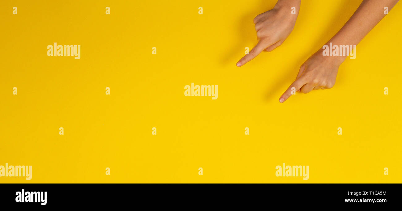 Child hands fingers pointing on yellow background Stock Photo - Alamy