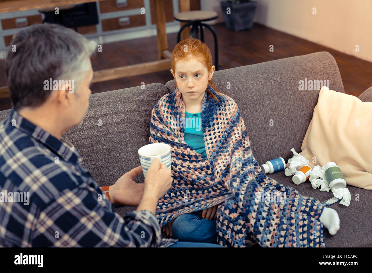 Serious gloomy girl looking at her father Stock Photo - Alamy