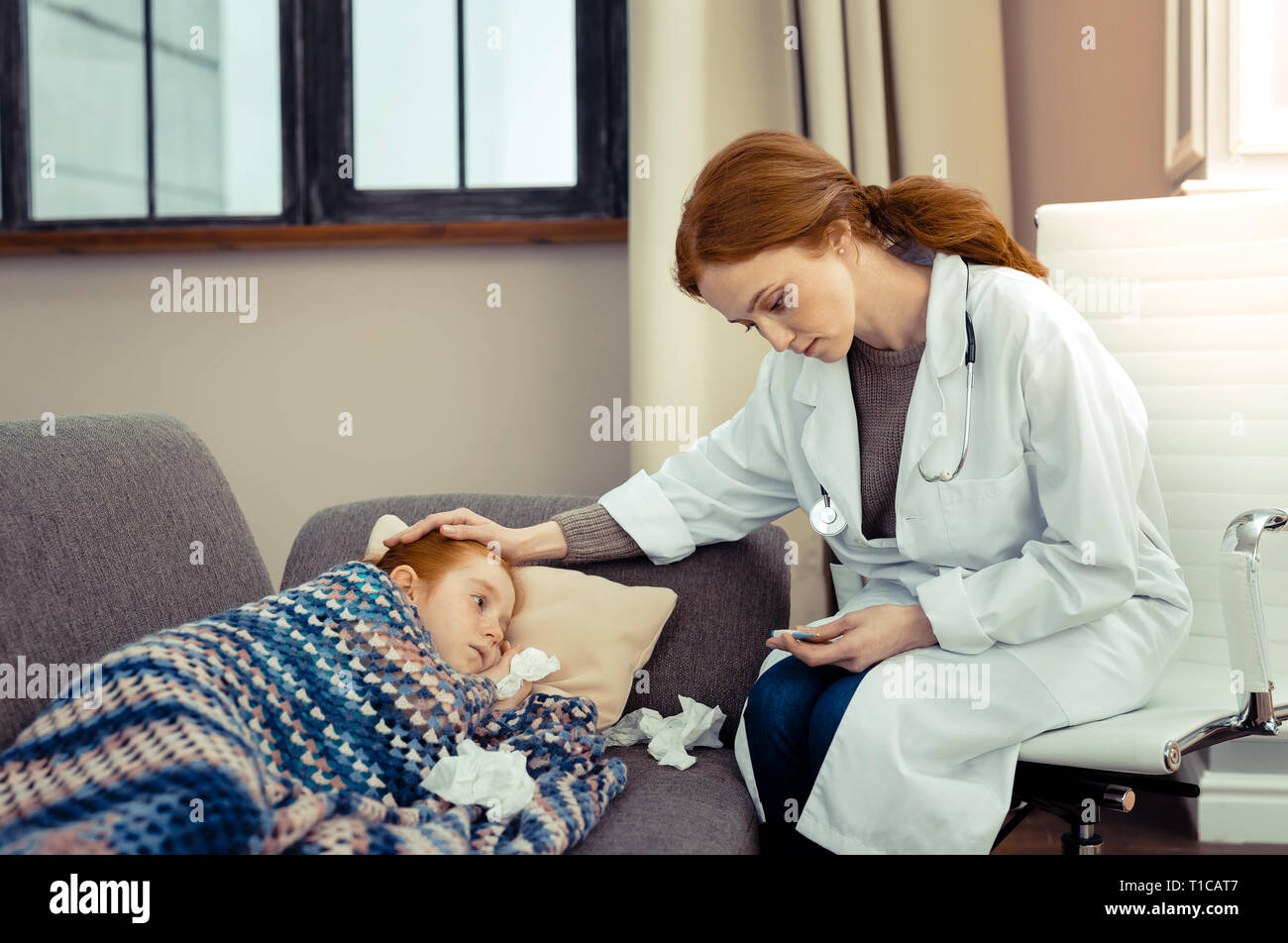 Nice serious doctor worrying about her patient Stock Photo - Alamy