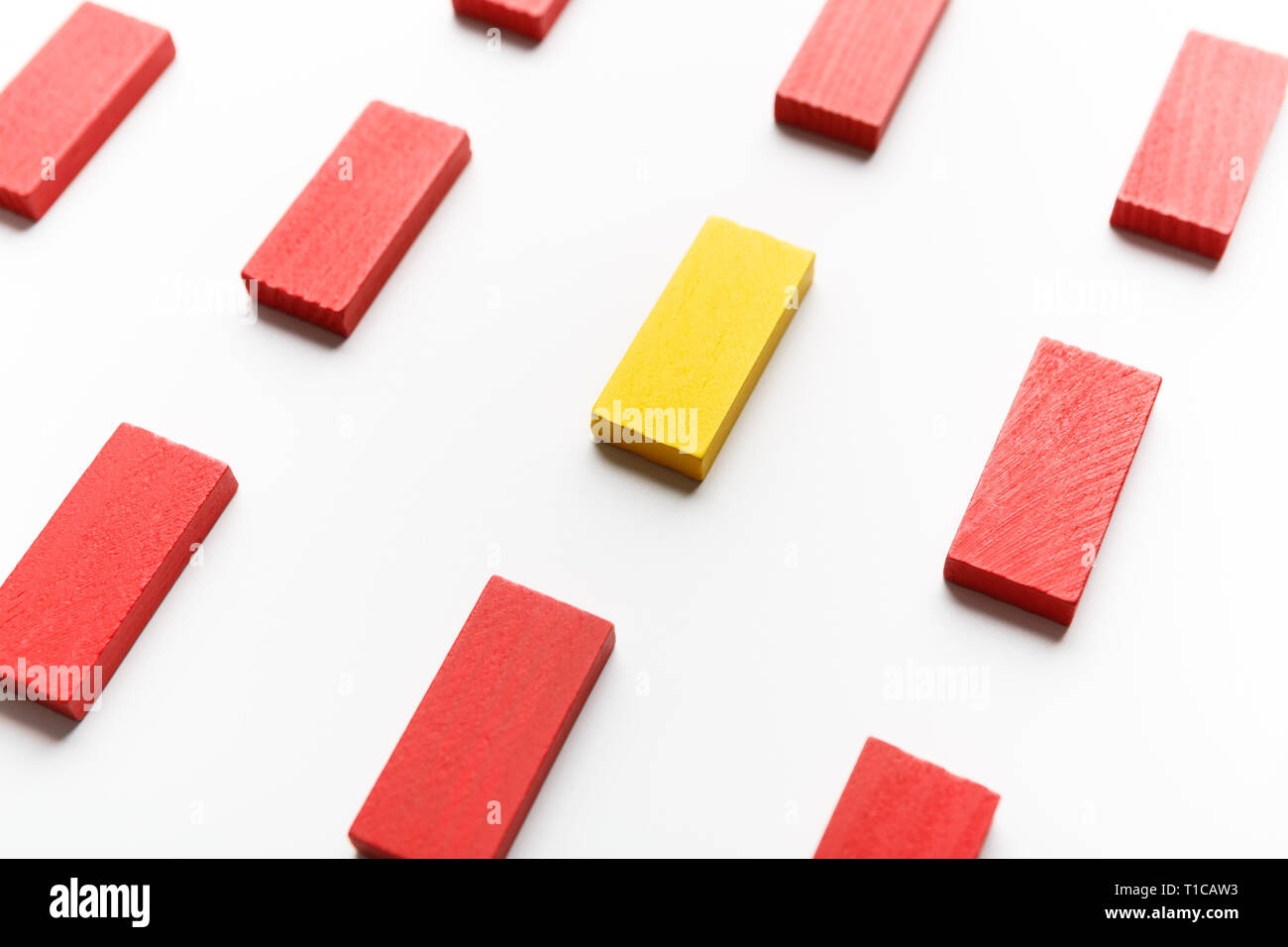 One yellow wooden block among red ones Stock Photo - Alamy