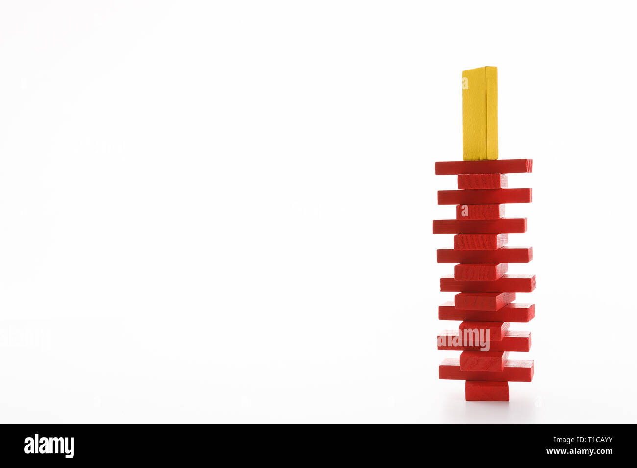 Yellow wooden block on top of stack of red ones Stock Photo - Alamy