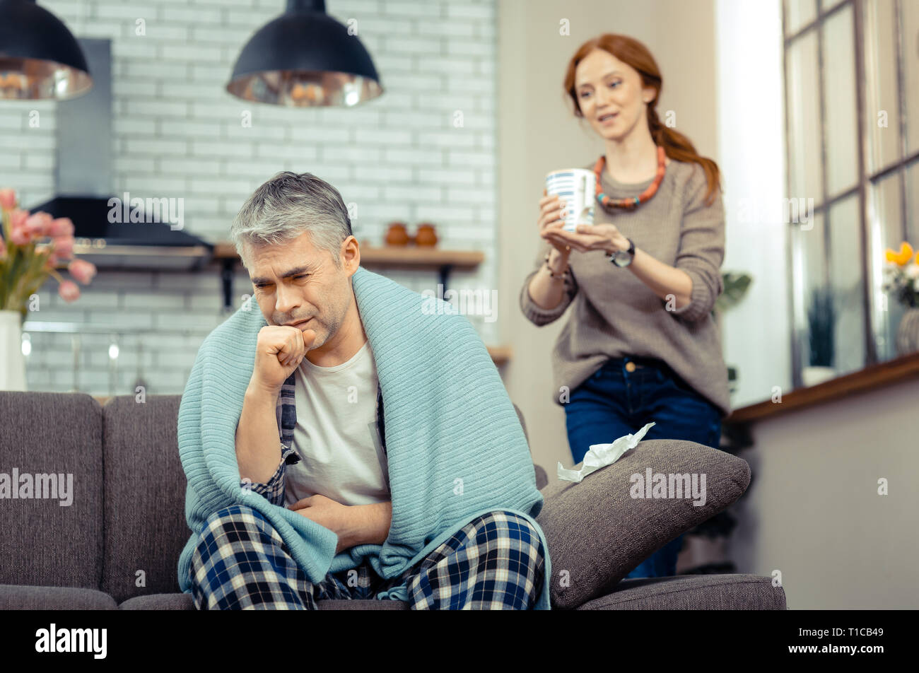 Sad cheerless man coughing into his fist Stock Photo - Alamy