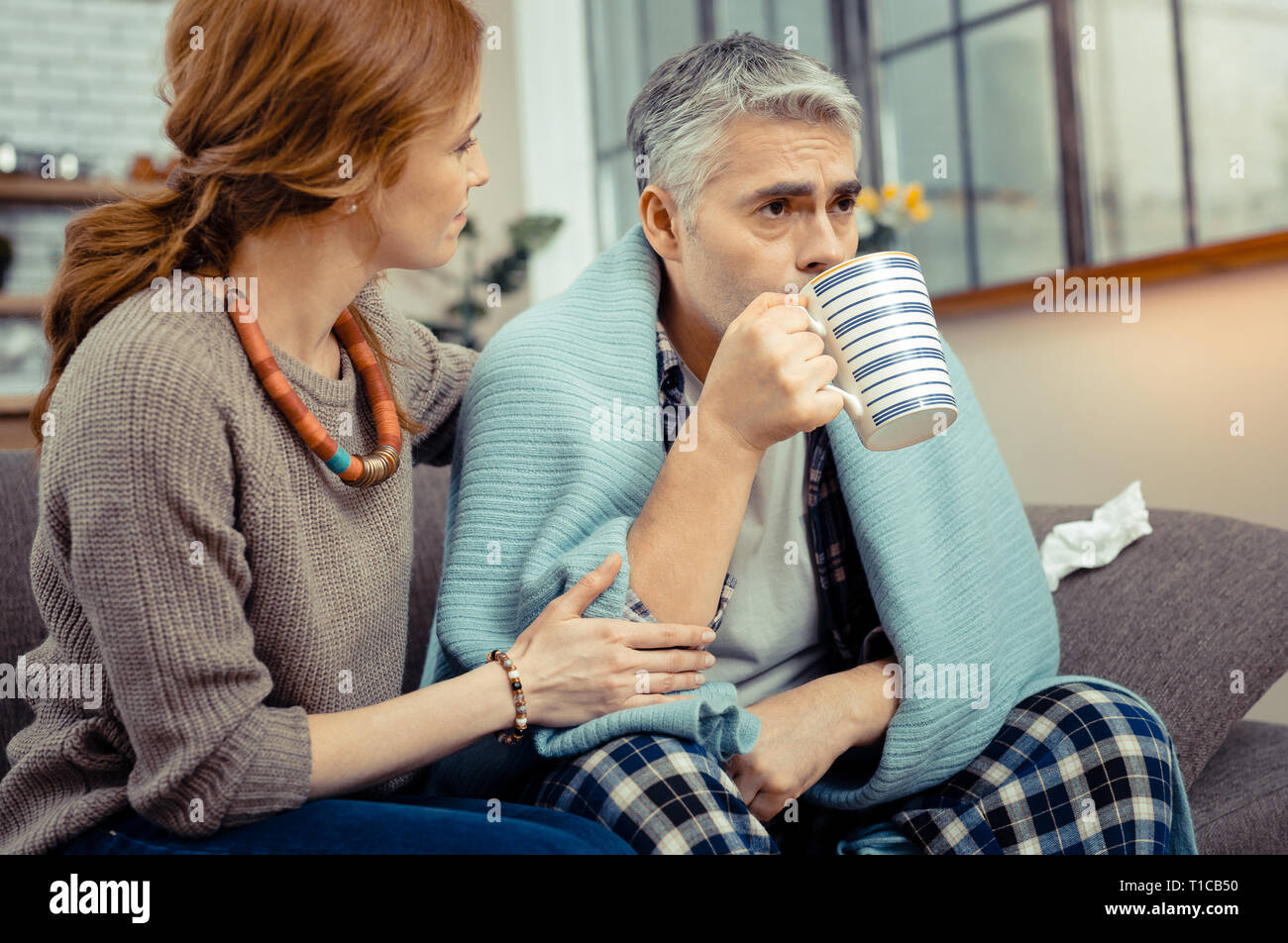 Nice sick man drinking hot tea with lemon Stock Photo - Alamy