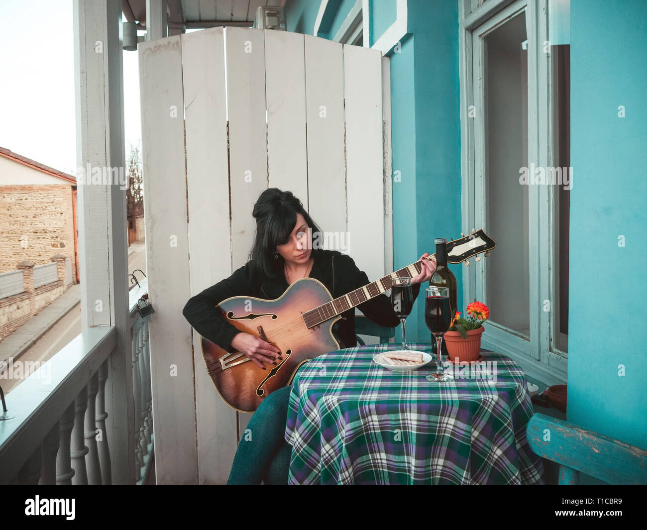 Woman playing guitar on vintage balcony Stock Photo - Alamy