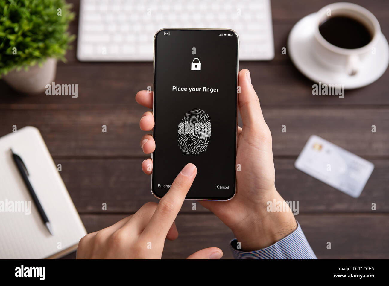Hand holding mobile phone with application for scanning fingerprint ...