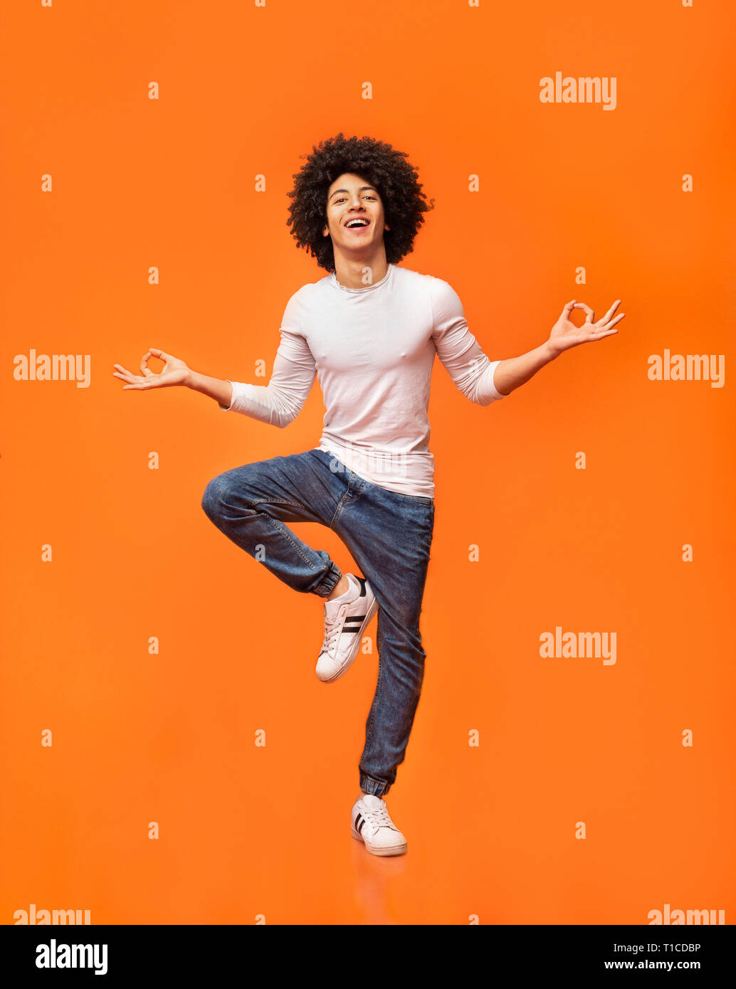 Funny young man sitting in mid air, balancing on one leg Stock Photo ...