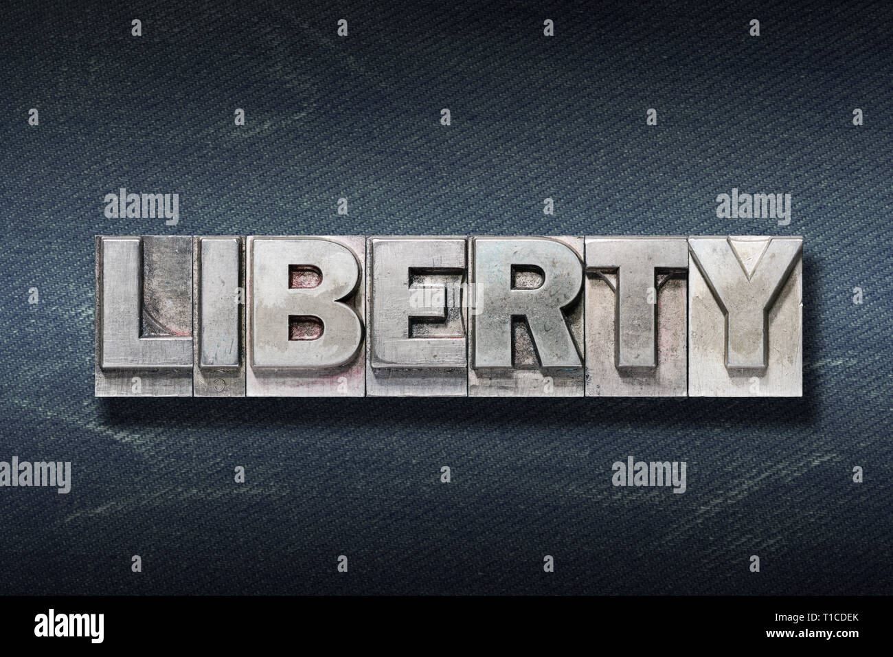 liberty word made from metallic letterpress on dark jeans background ...