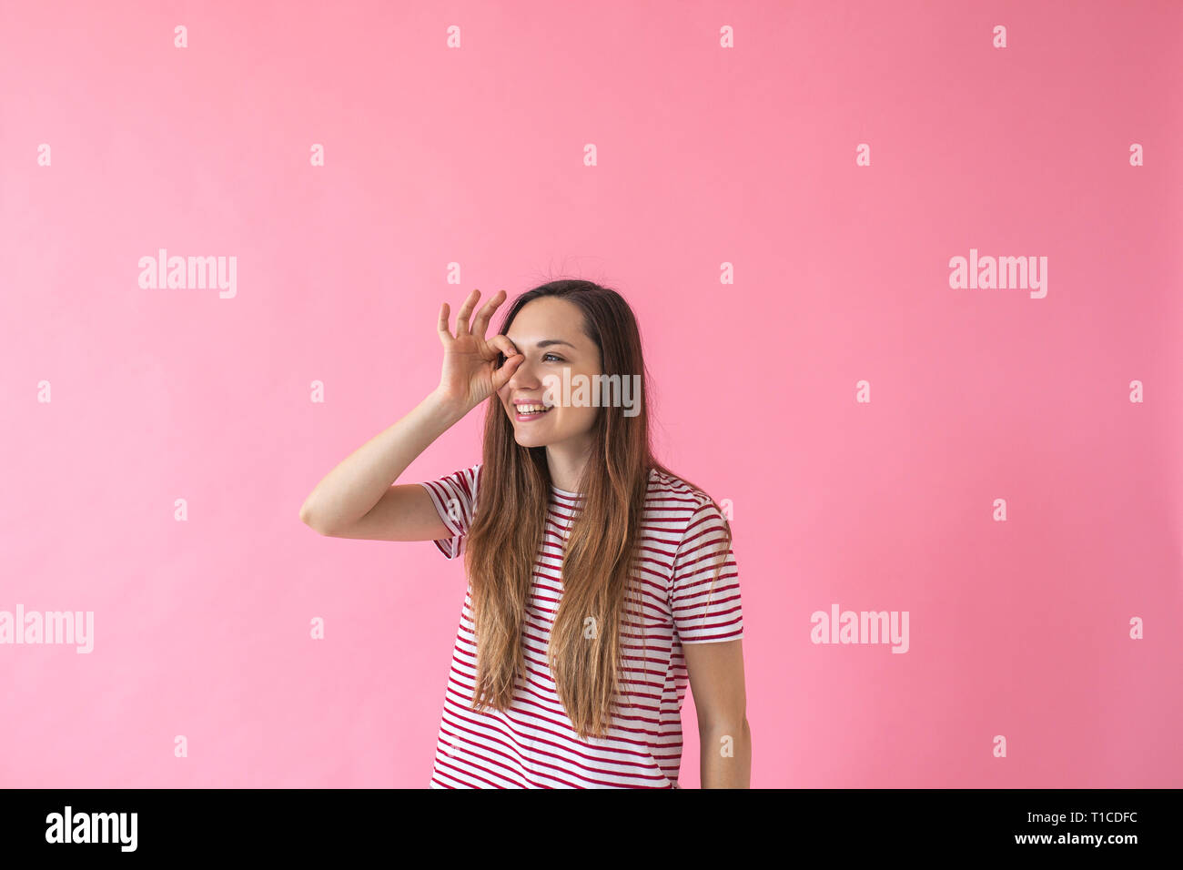 Positive beautiful young girl making a hand sign Stock Photo - Alamy