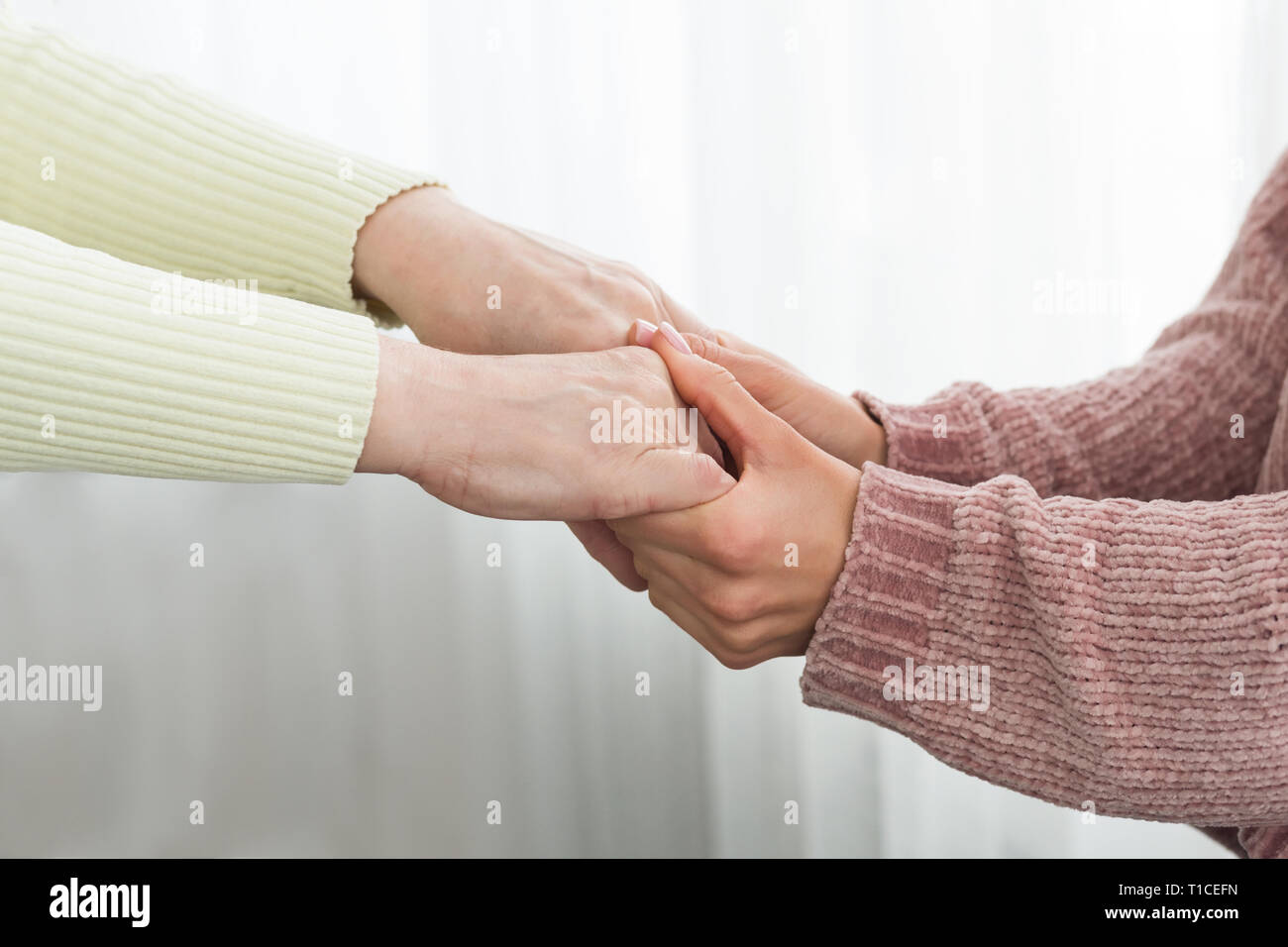 Family support. Senior woman and daughter holding hands Stock Photo - Alamy