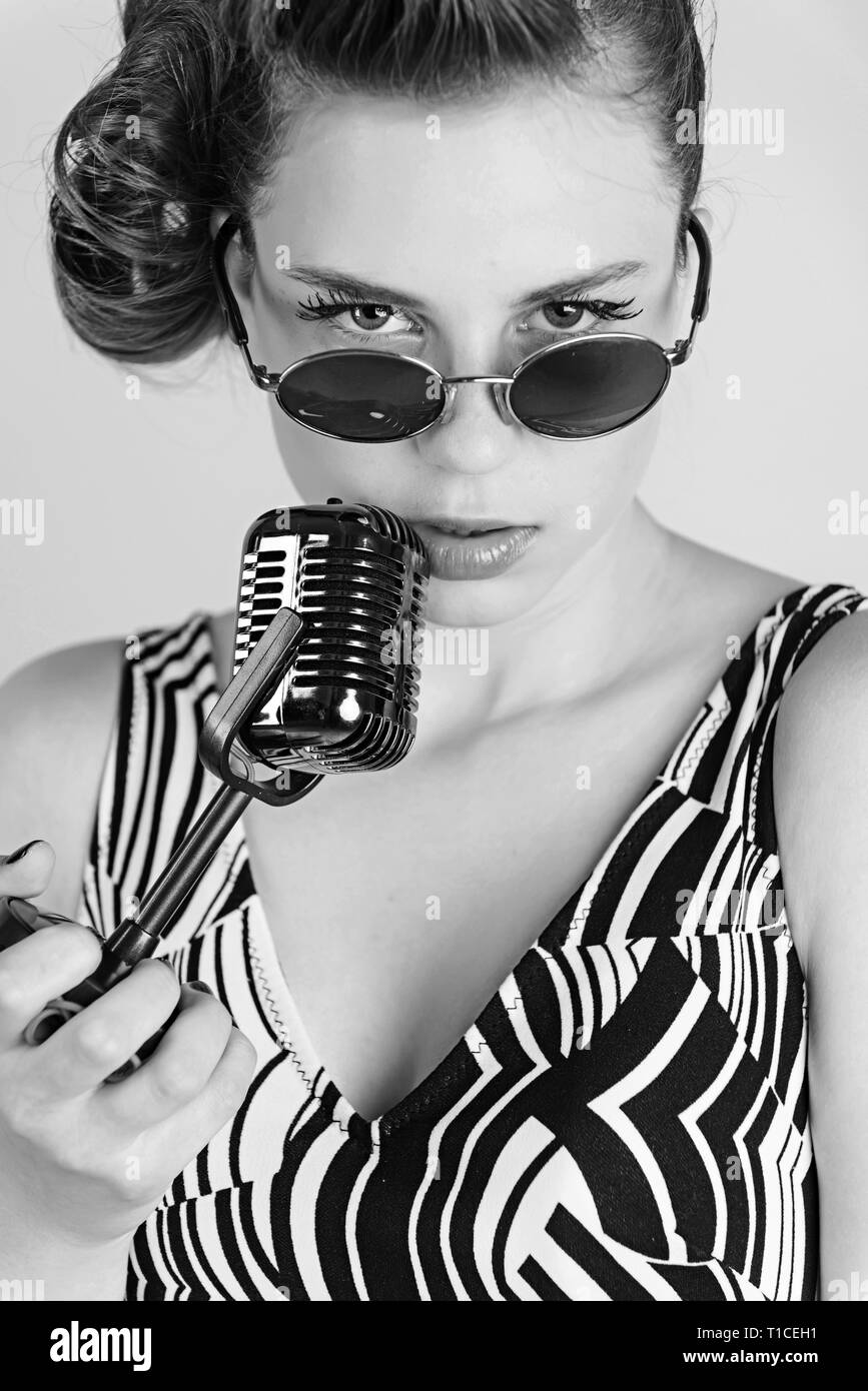 Girl in glasses sing in microphone Stock Photo - Alamy