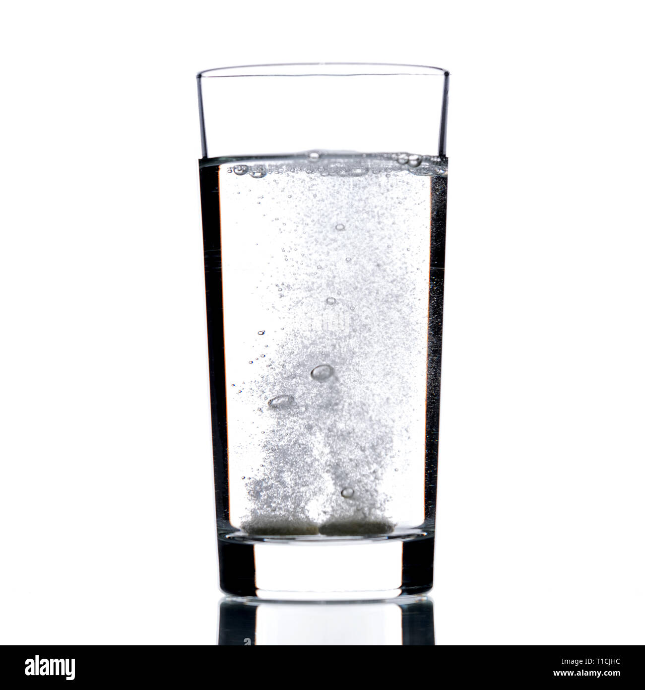 Two fizzy pills in the glass of water. Isolated on a white background ...
