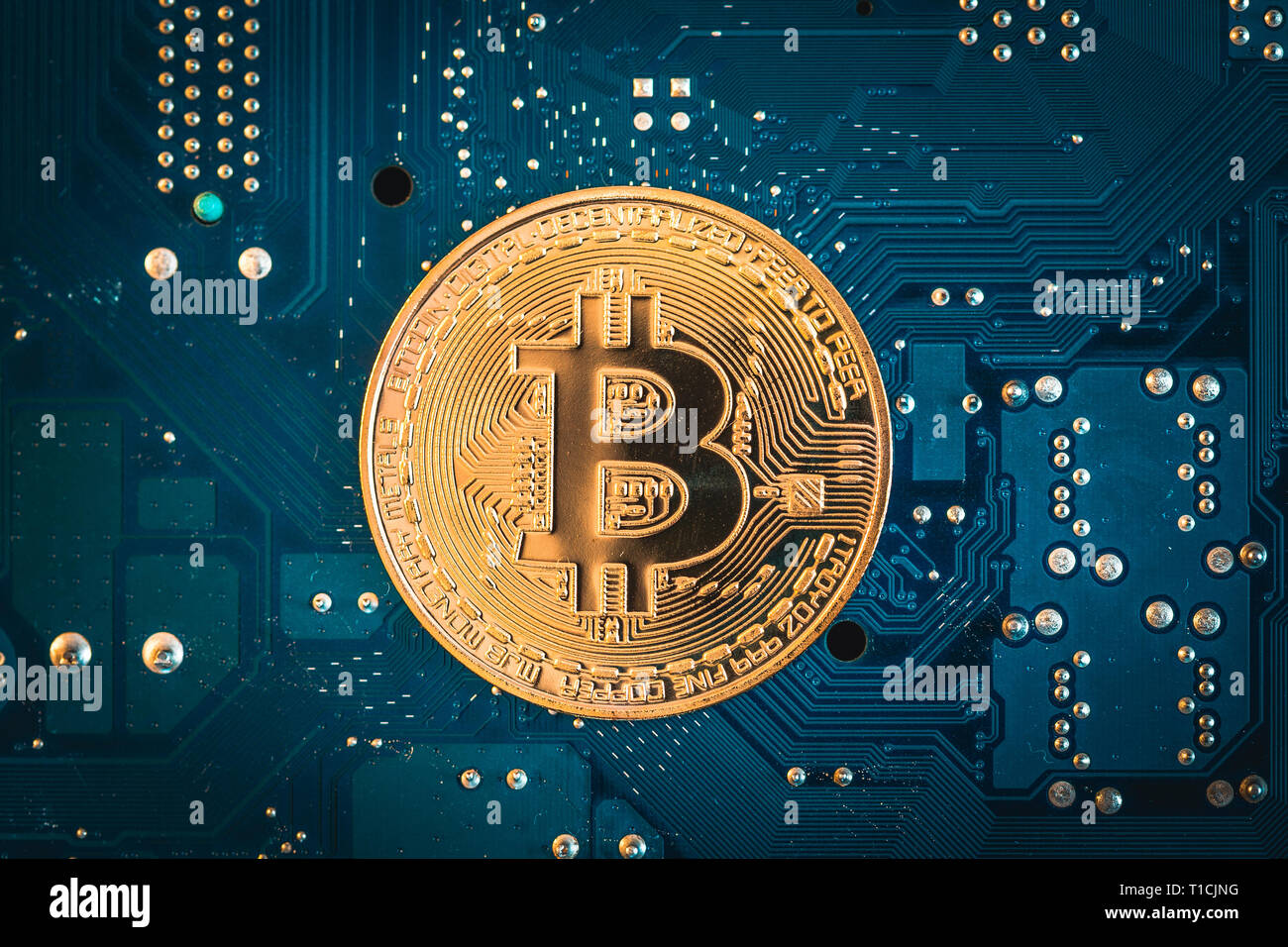 Mining Bitcoin concept - gold coin on a blue printed circuit board ...