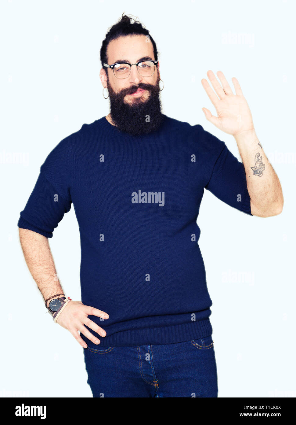 Young hipster man with long hair and beard wearing glasses Waiving ...