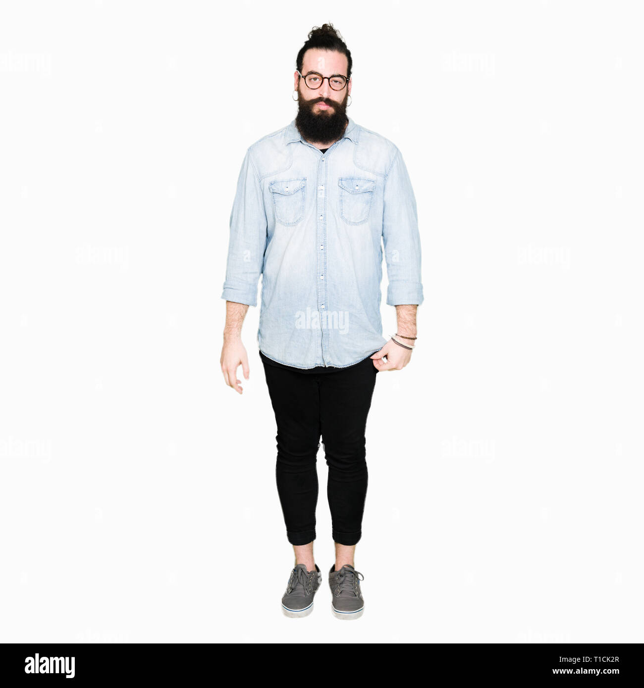 Young hipster man with long hair and beard wearing glasses depressed ...
