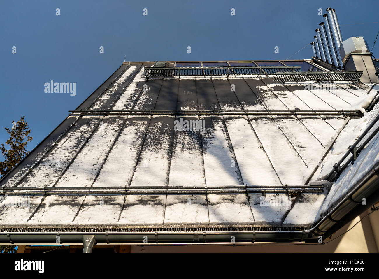 Tin roof on which lies the snow, visible facade of the building, gutter ...