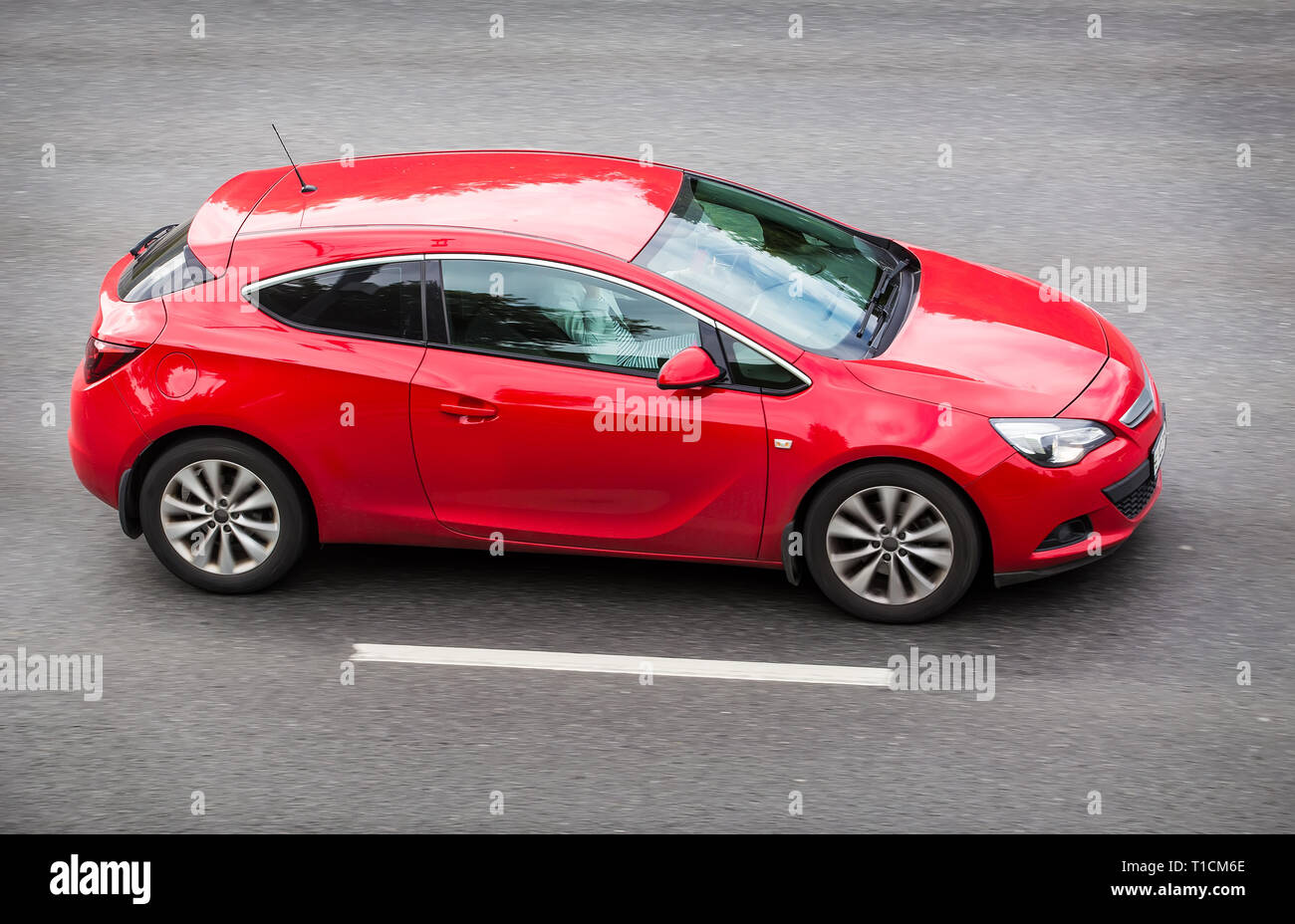 red car goes on city street Stock Photo - Alamy
