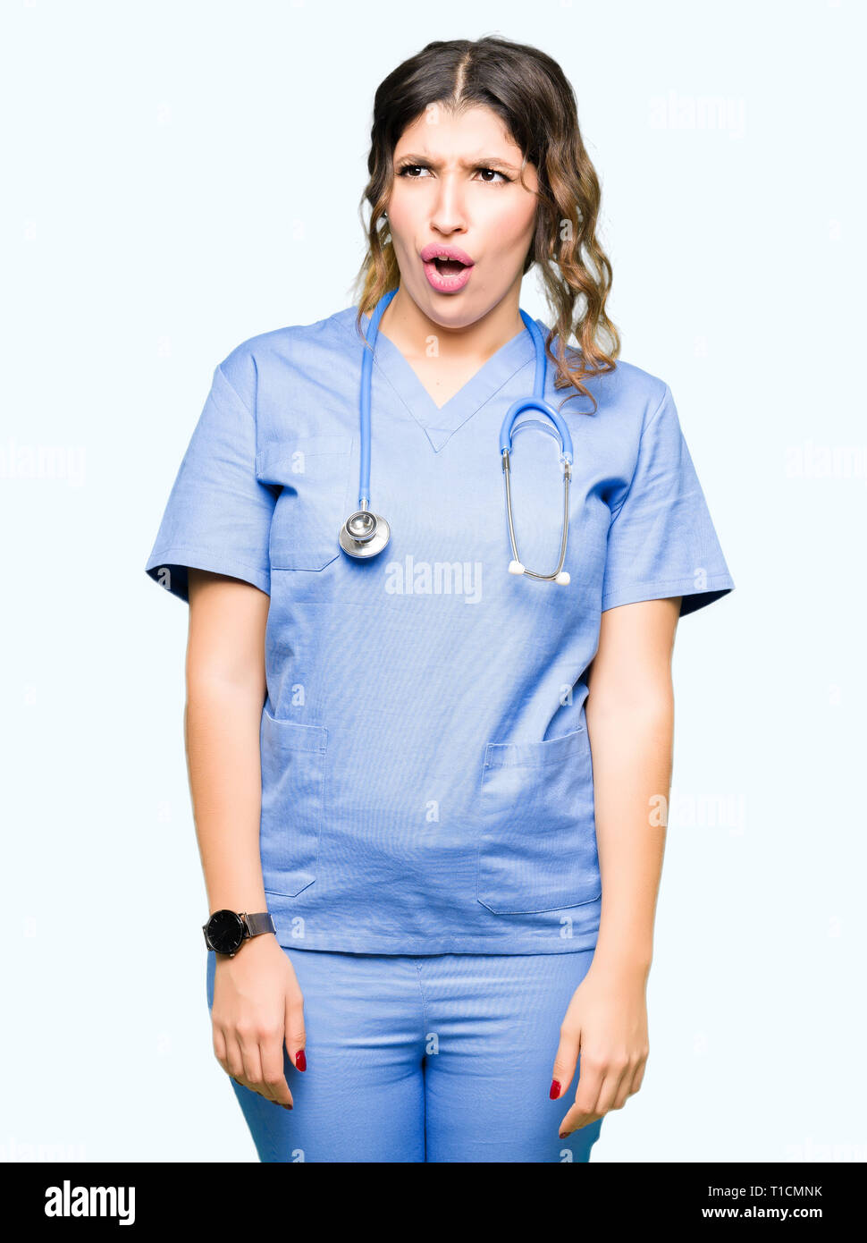 Young adult doctor woman wearing medical uniform In shock face, looking ...