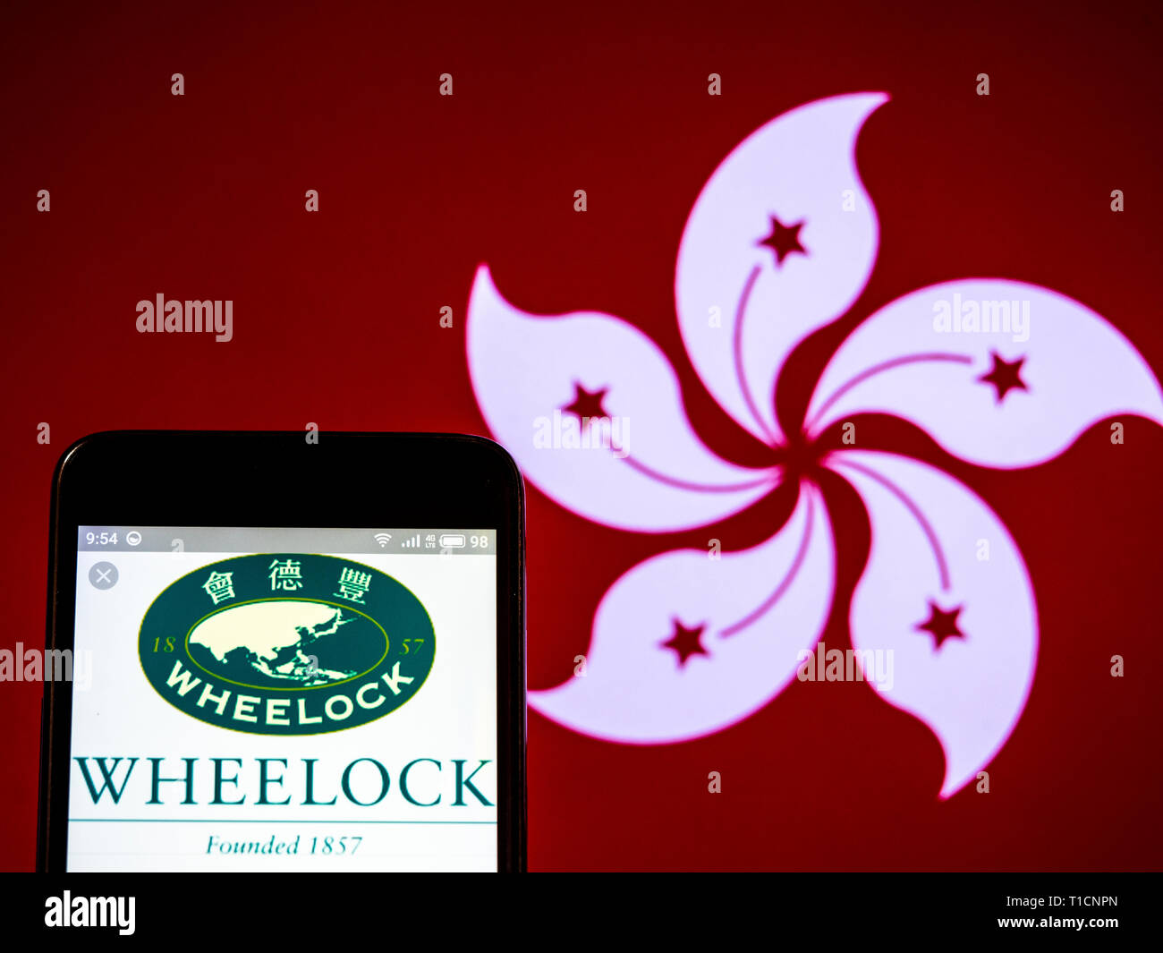In this photo illustration a Wheelock & Co logo seen displayed on a ...