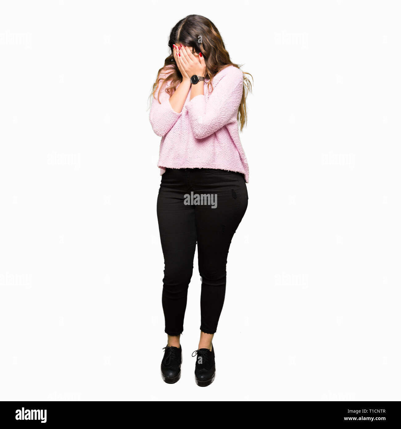 Young beautiful woman wearing pink sweater with sad expression covering ...