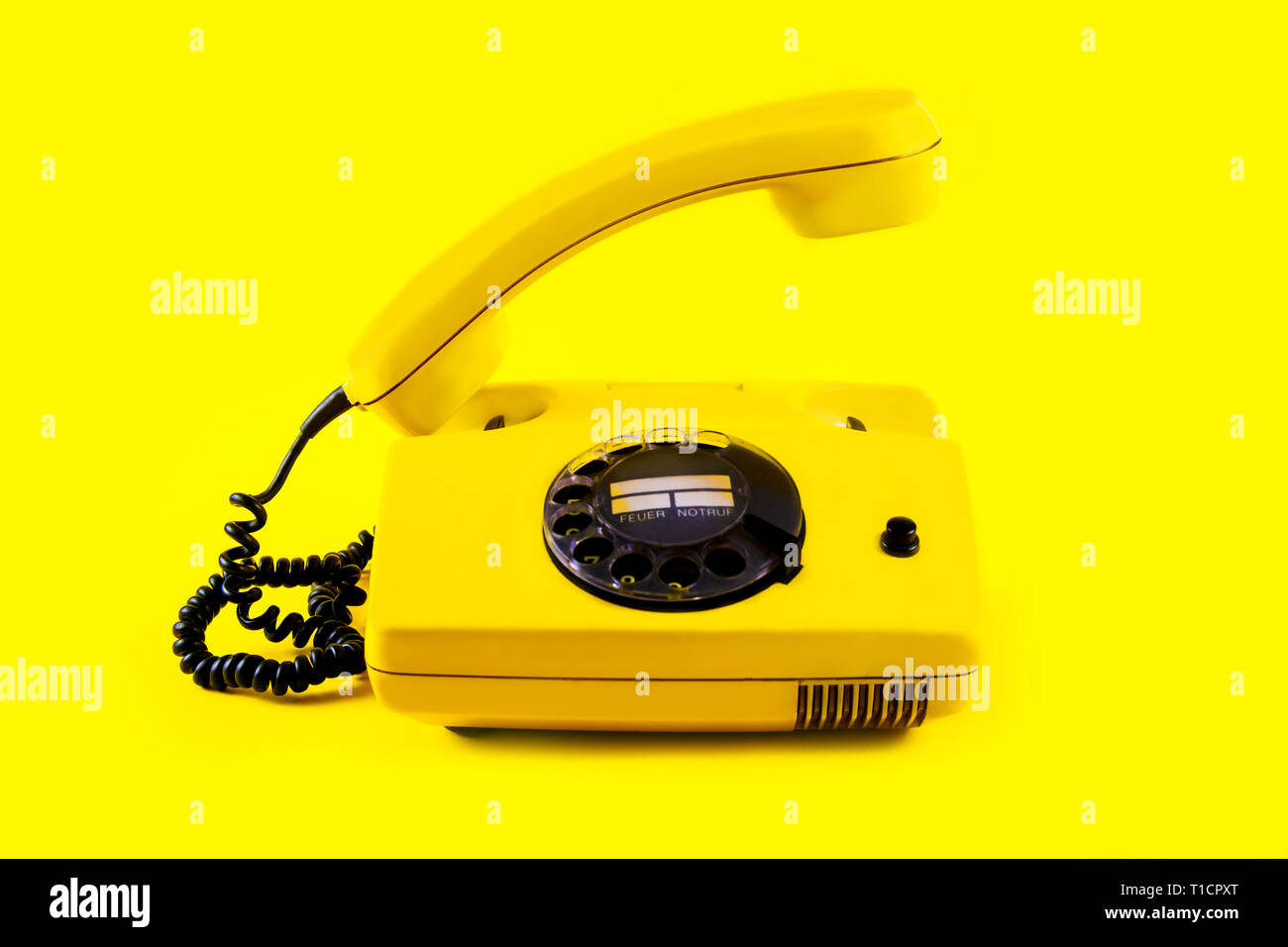 Yellow vintage phone on yellow background. Retro telephone with raised ...