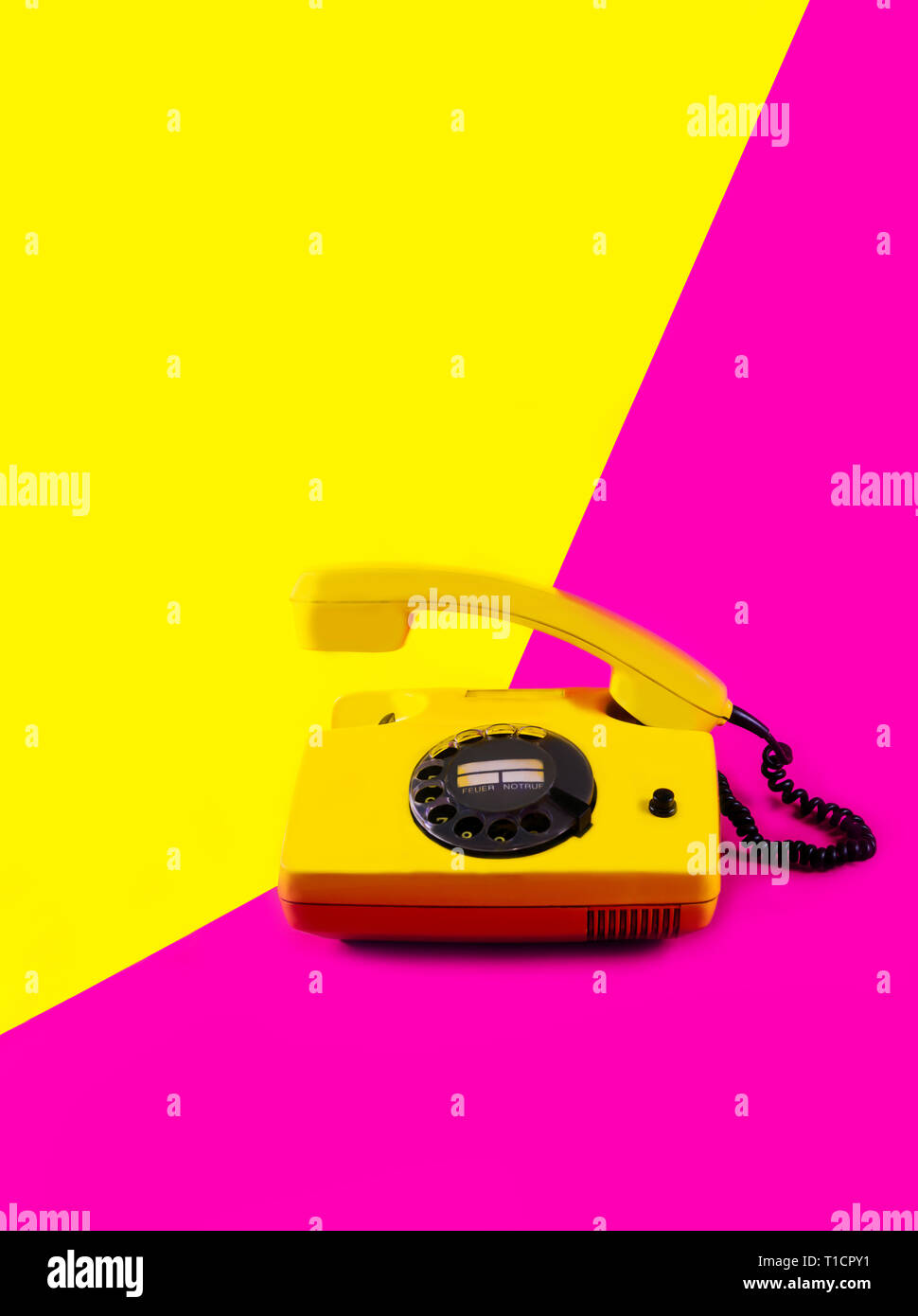 Yellow vintage phone on yellow and pink background. Retro telephone on ...