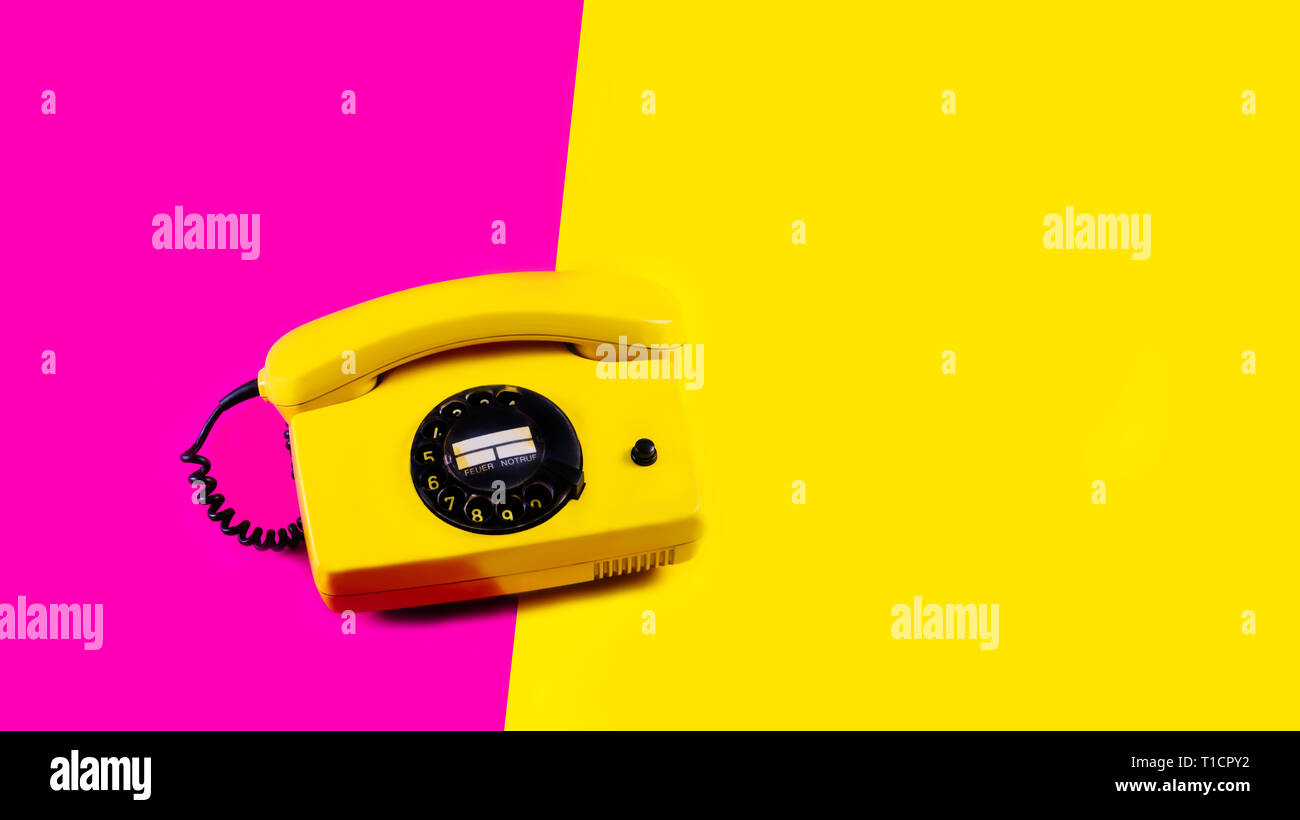 Yellow vintage phone on yellow and pink background. Retro telephone on ...