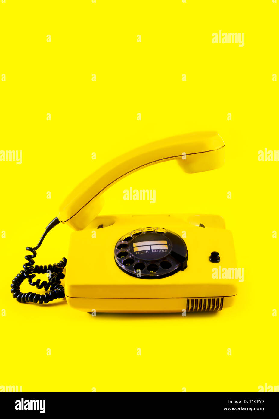 Yellow vintage phone on yellow background. Retro telephone with raised ...