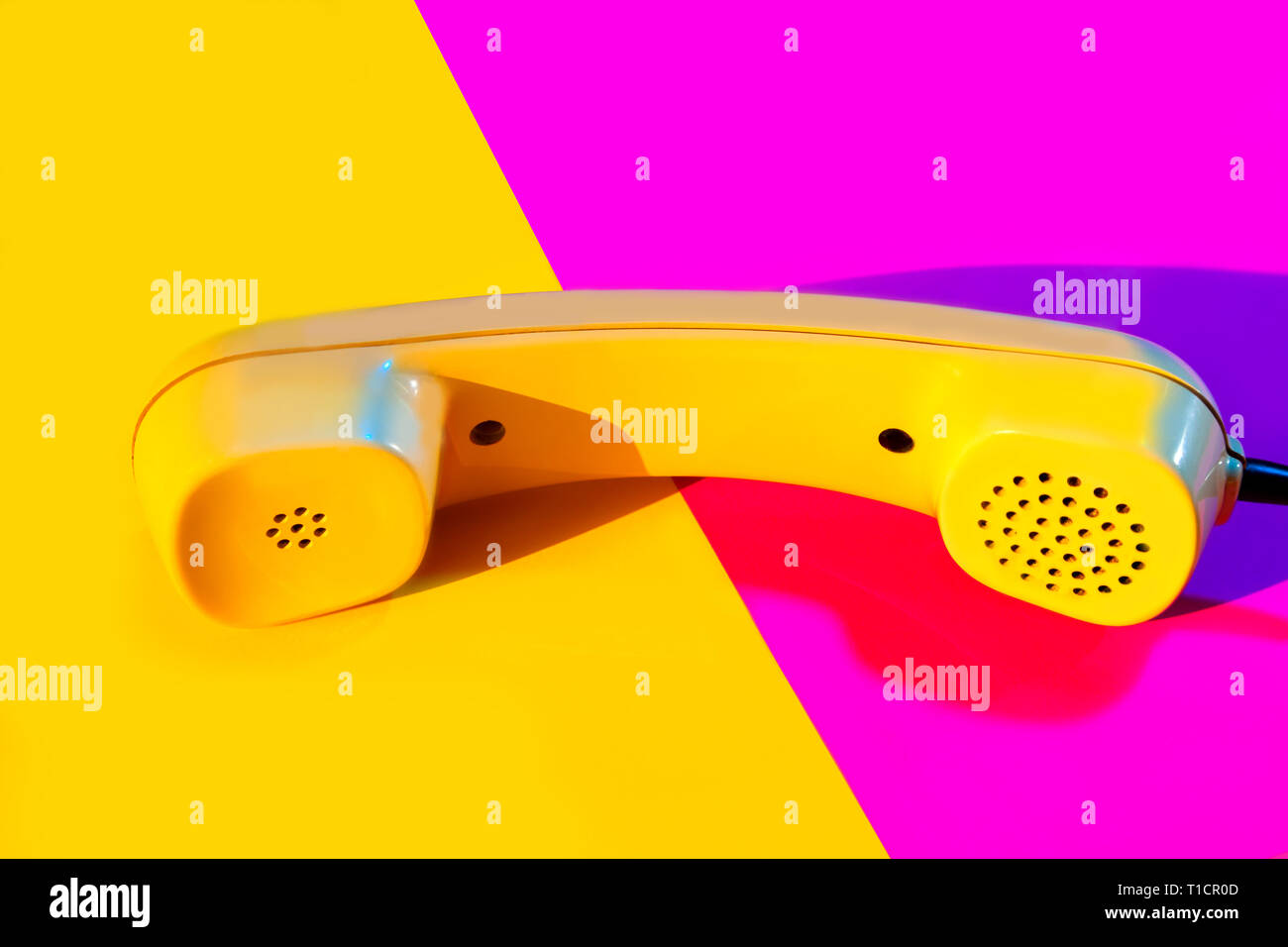 Yellow vintage phone on yellow and pink background. Retro telephone on ...