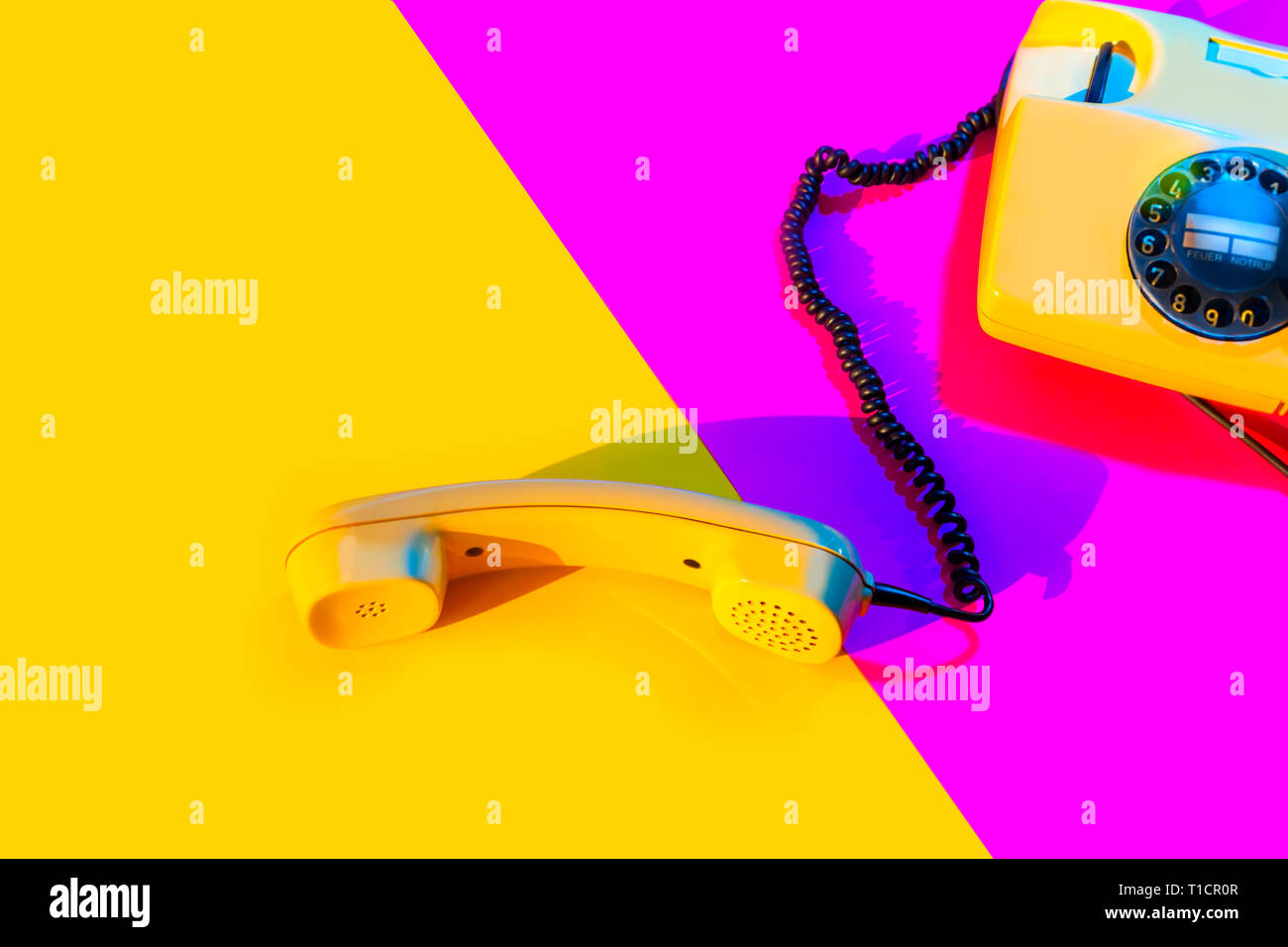 Yellow vintage phone on yellow and pink background. Retro telephone on ...