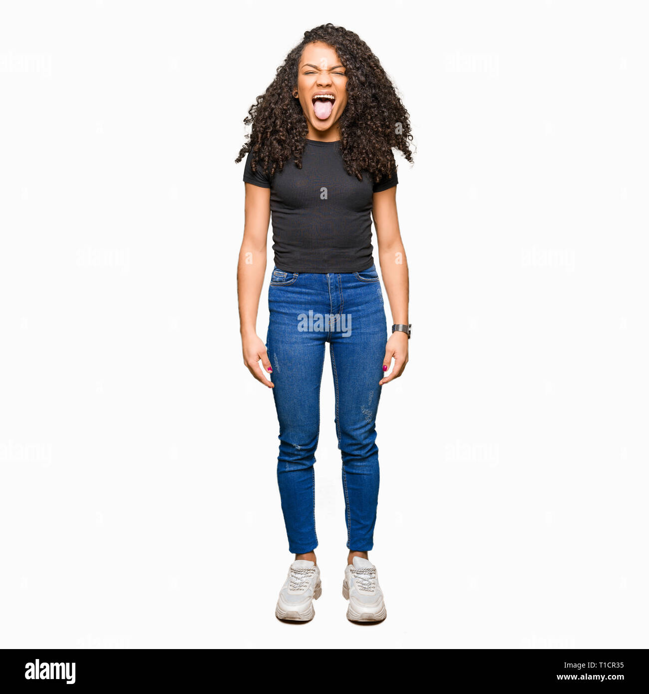 Young Beautiful Woman With Curly Hair Sticking Tongue Out Happy With