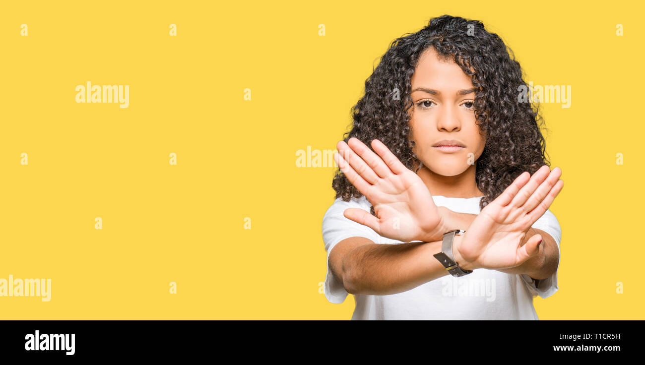 Young beautiful woman with curly hair wearing white t-shirt Rejection ...
