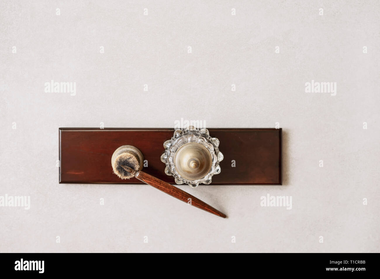 Old wooden pen with feather and inkwell and inkwell on light background ...