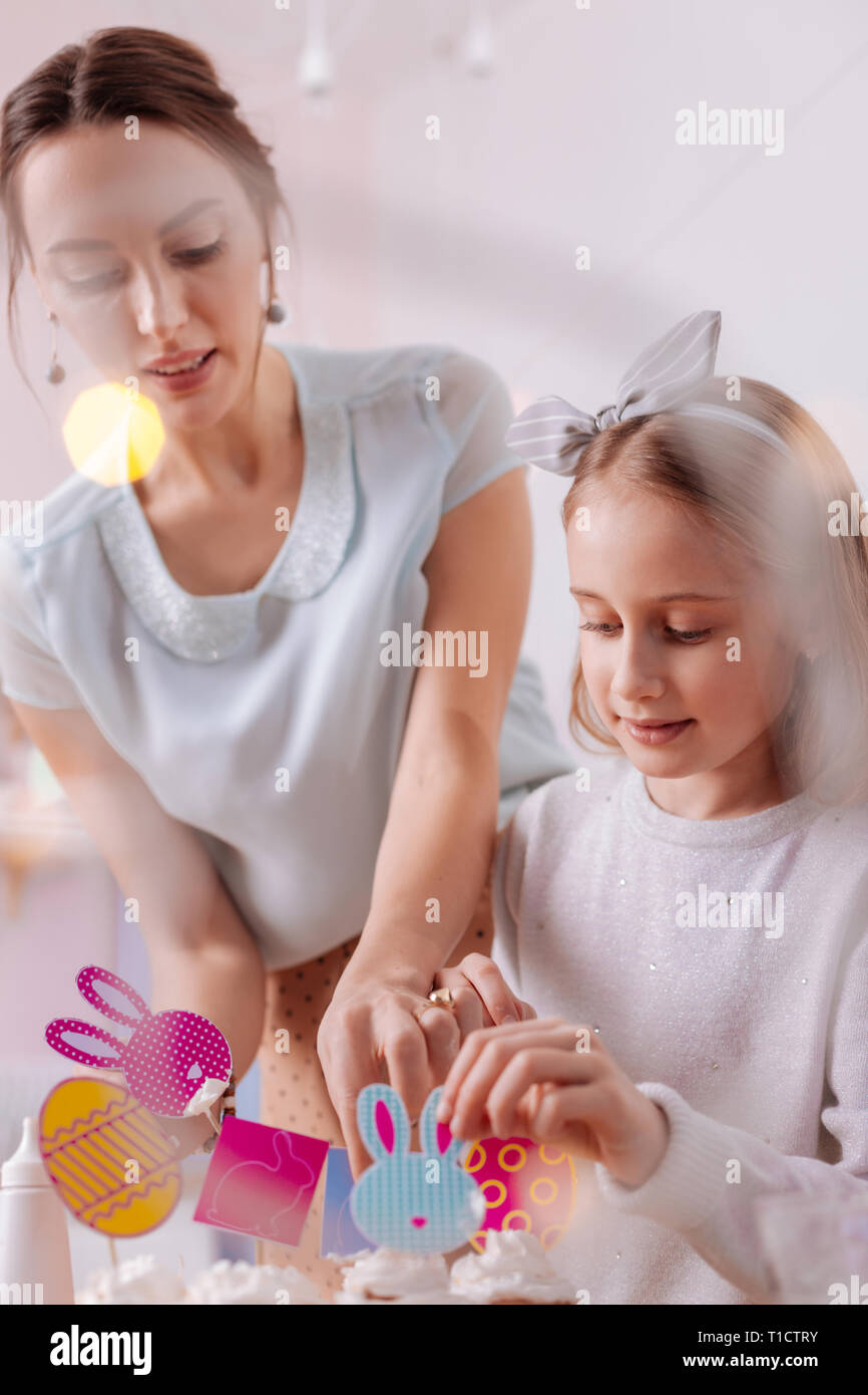 Kind blonde girl standing close to her mother Stock Photo - Alamy